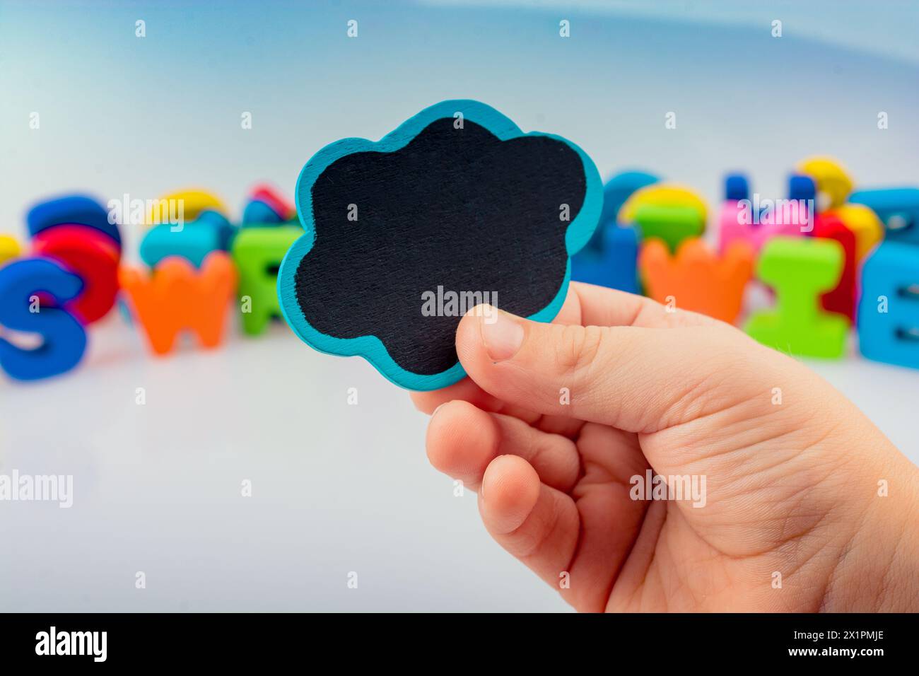 Speech bubble in hand with colorful letters behind Stock Photo - Alamy