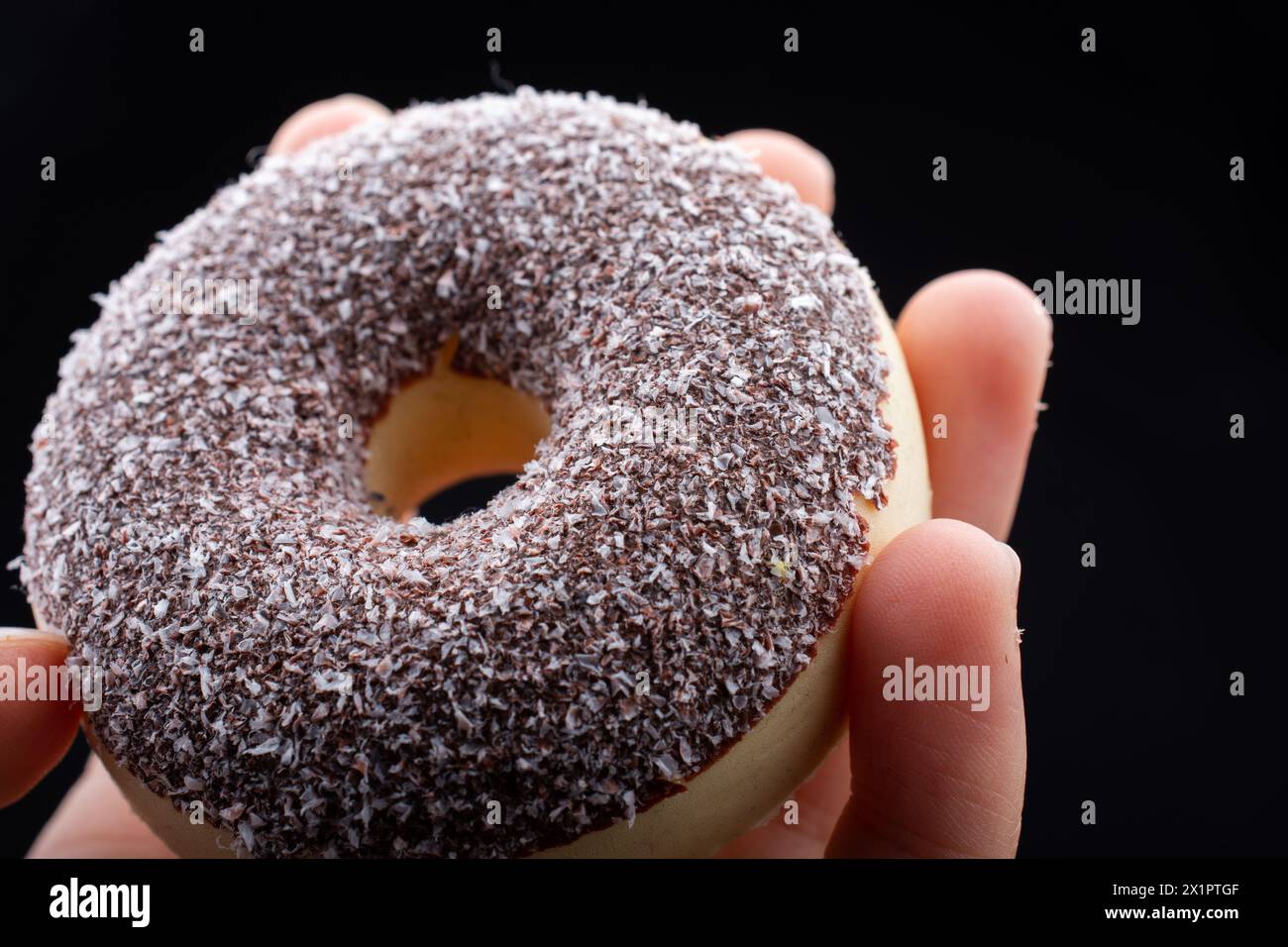 Hand holding a Fake plastic donuts in black background Stock Photo - Alamy