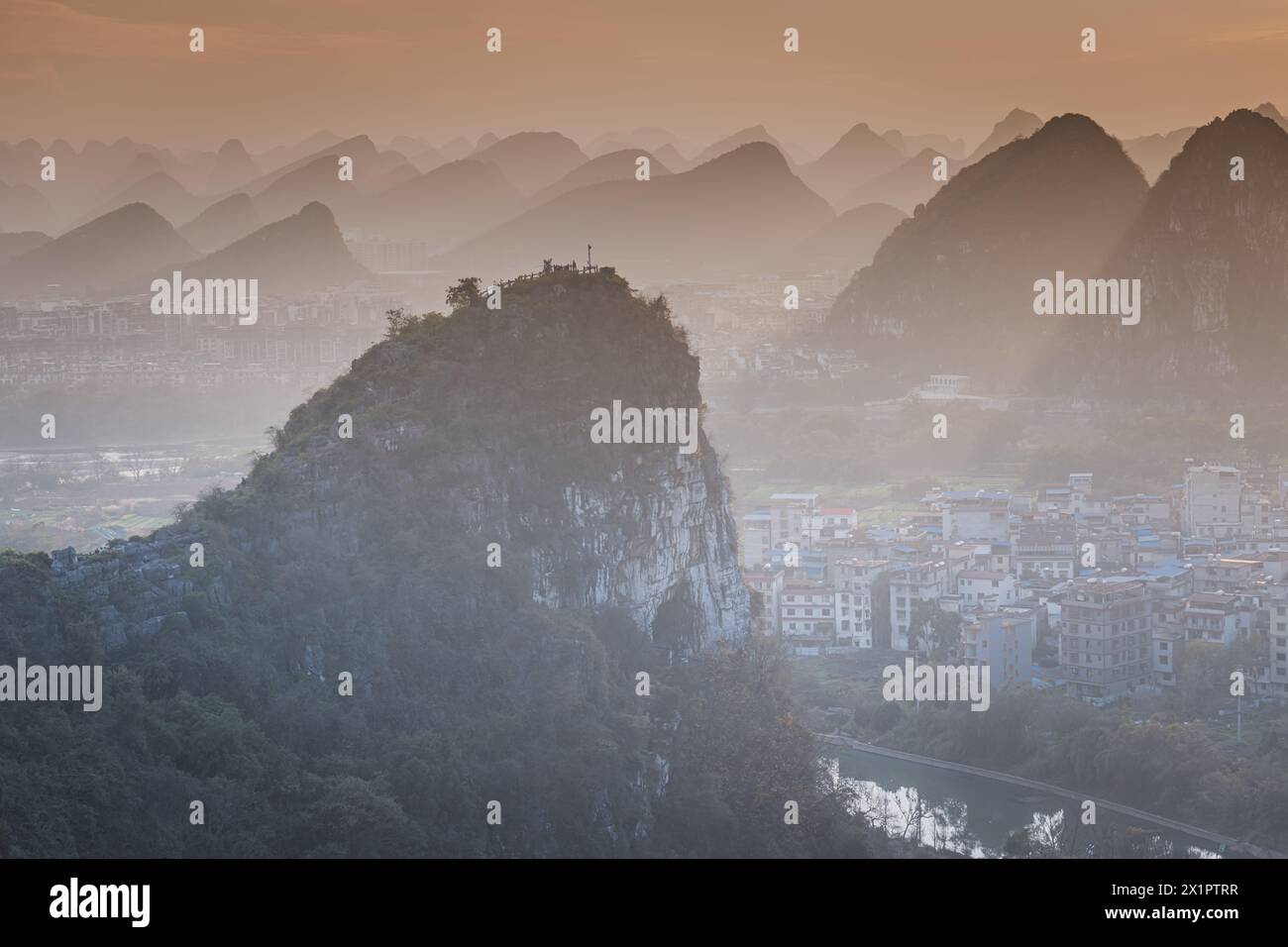 Limestone mountains at the sunset surrounded by the city buildings ...