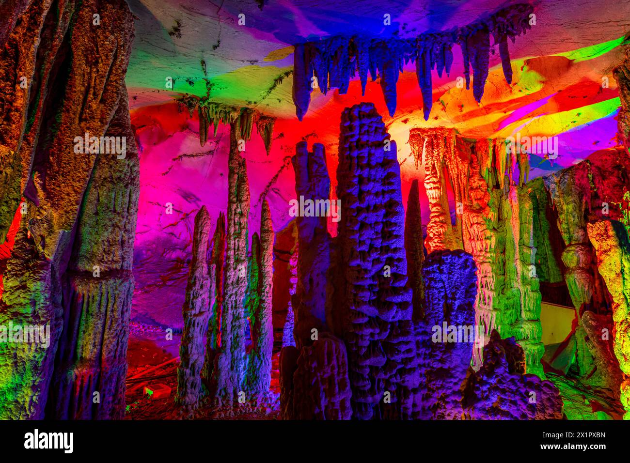 Inside the cave. Stalactites, stalagmites, colored light. Beautiful ...
