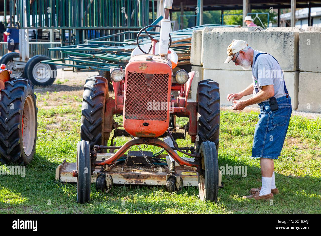 An elderly farmer prepares his antique Allis Chalmers Model B row crop ...