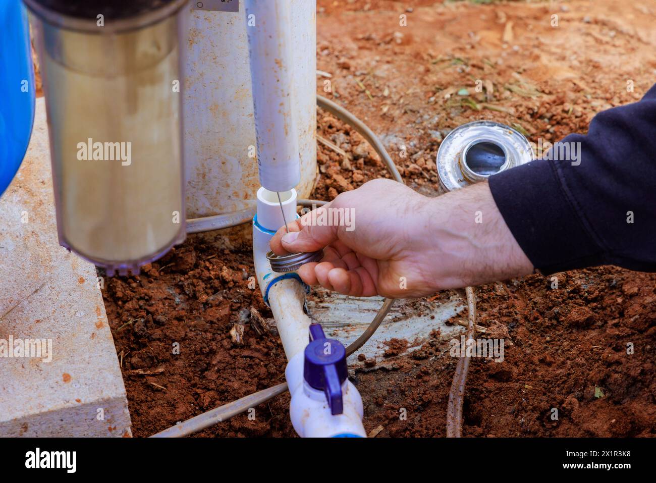 Technician plumber uses clear primer for PVC pipe before gluing it ...