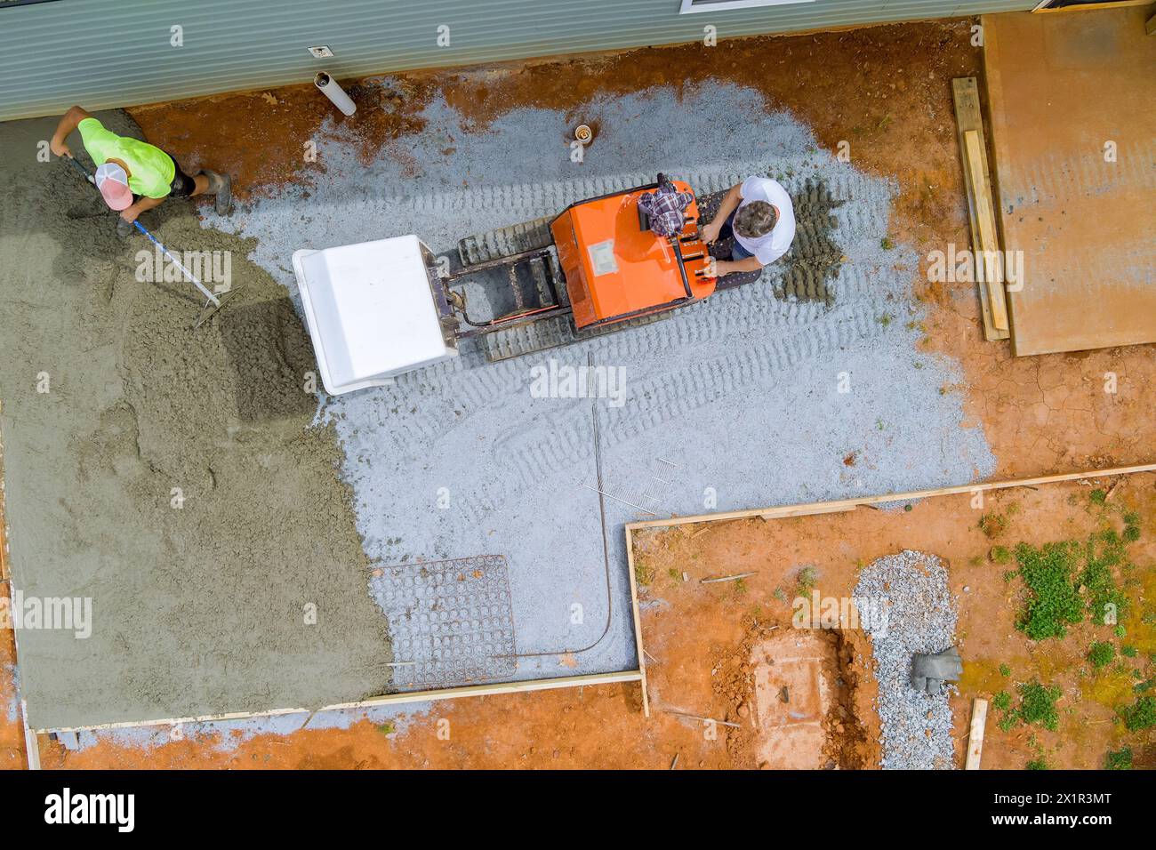 Wet cement is poured into framework during foundation construction ...
