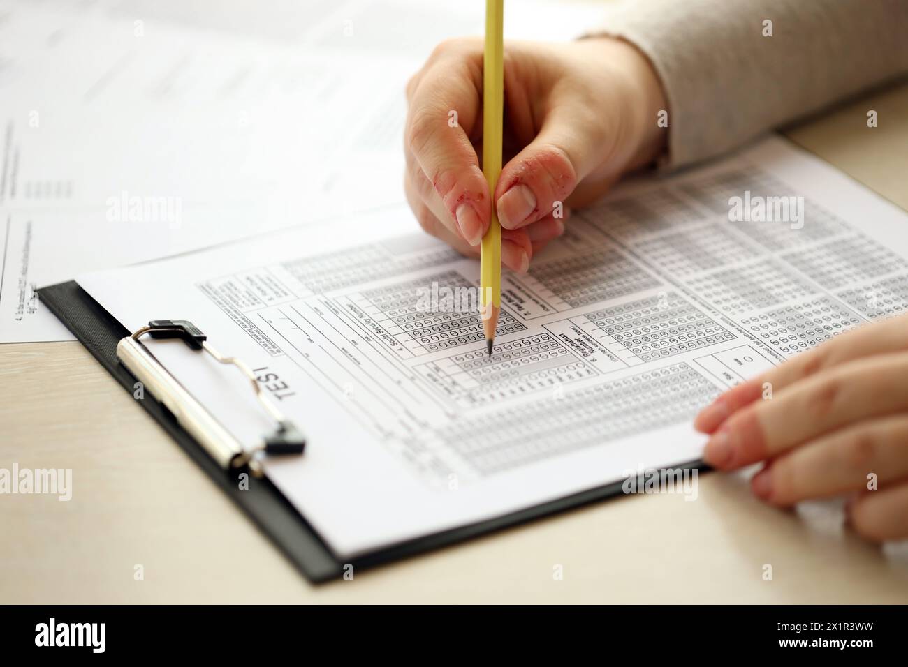 Female student hands testing in exercise and taking fill in exam paper ...