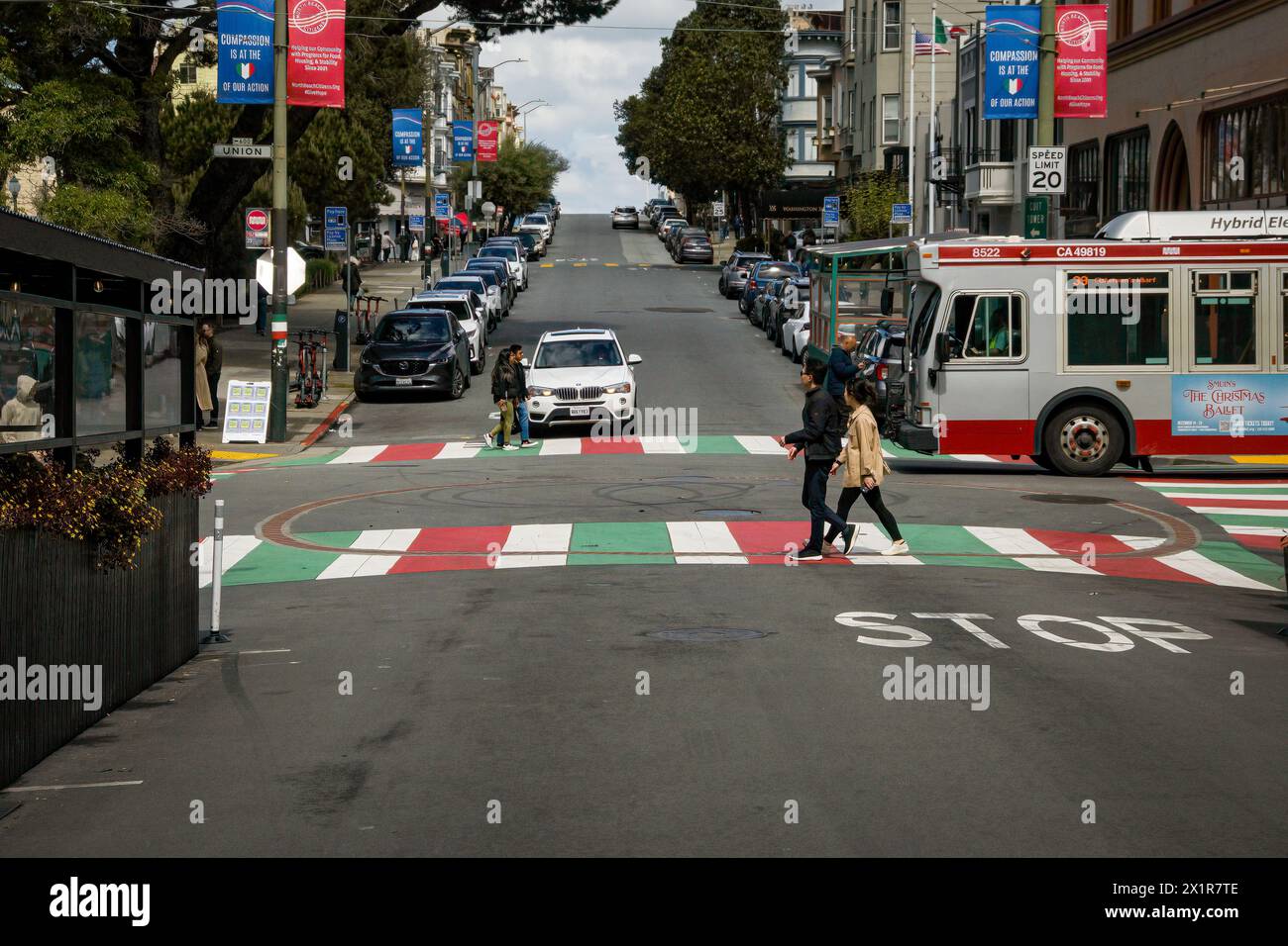 People walk on a red, white and green crosswalk on Union St. in the ...