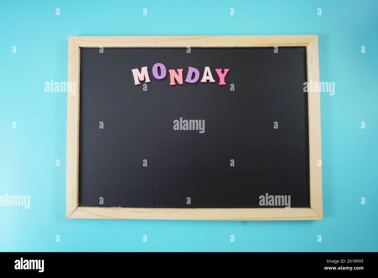monday wooden letter alphabet on black board Stock Photo - Alamy