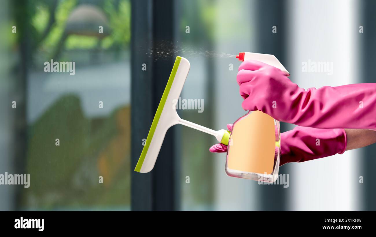 Human hand in protective glove using a cleaner in a spray bottle to ...