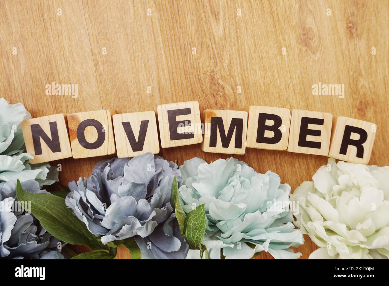 november alphabet letters with flower bouquet on wooden background ...