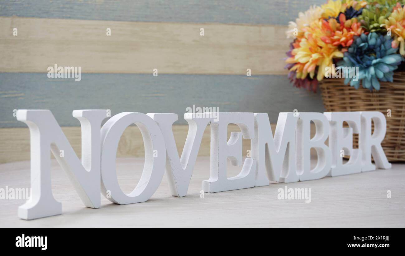 November alphabet letters and flower with space for copy on wooden ...
