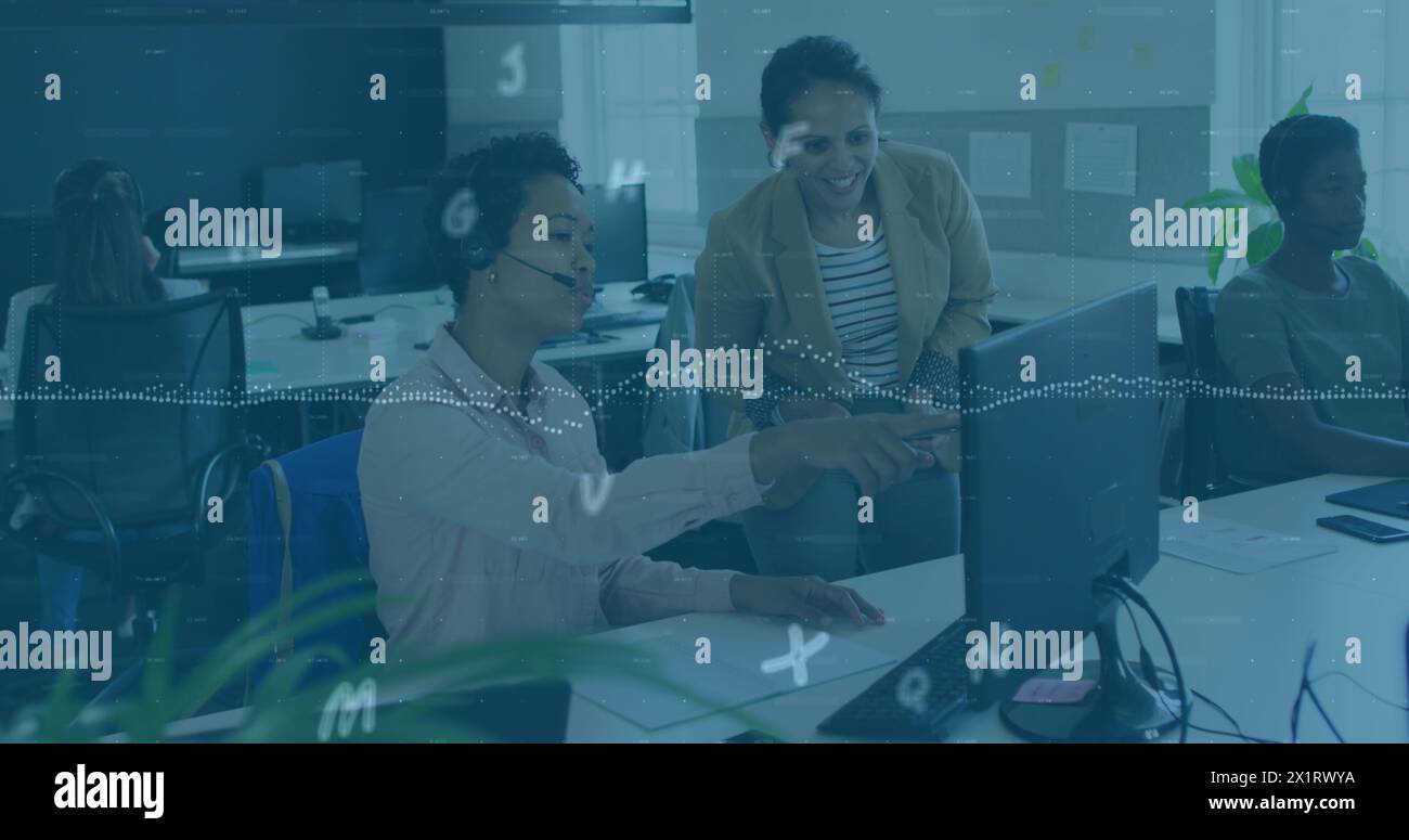 Diverse team working together, pointing at computer screen Stock Photo ...