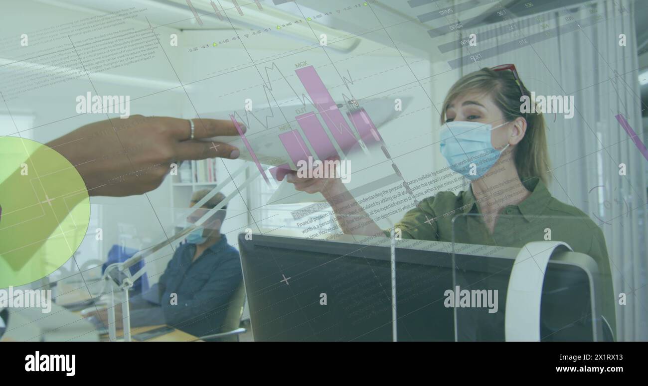 Diverse team analyzing business charts, wearing masks Stock Photo - Alamy