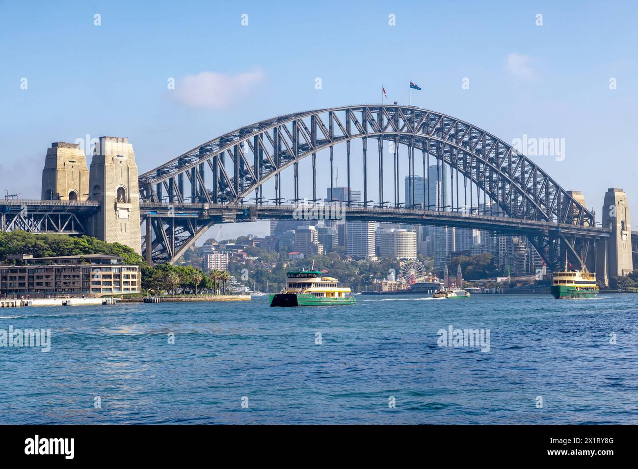 The iconic Sydney Harbour Bridge with passenger ferries crossing back ...