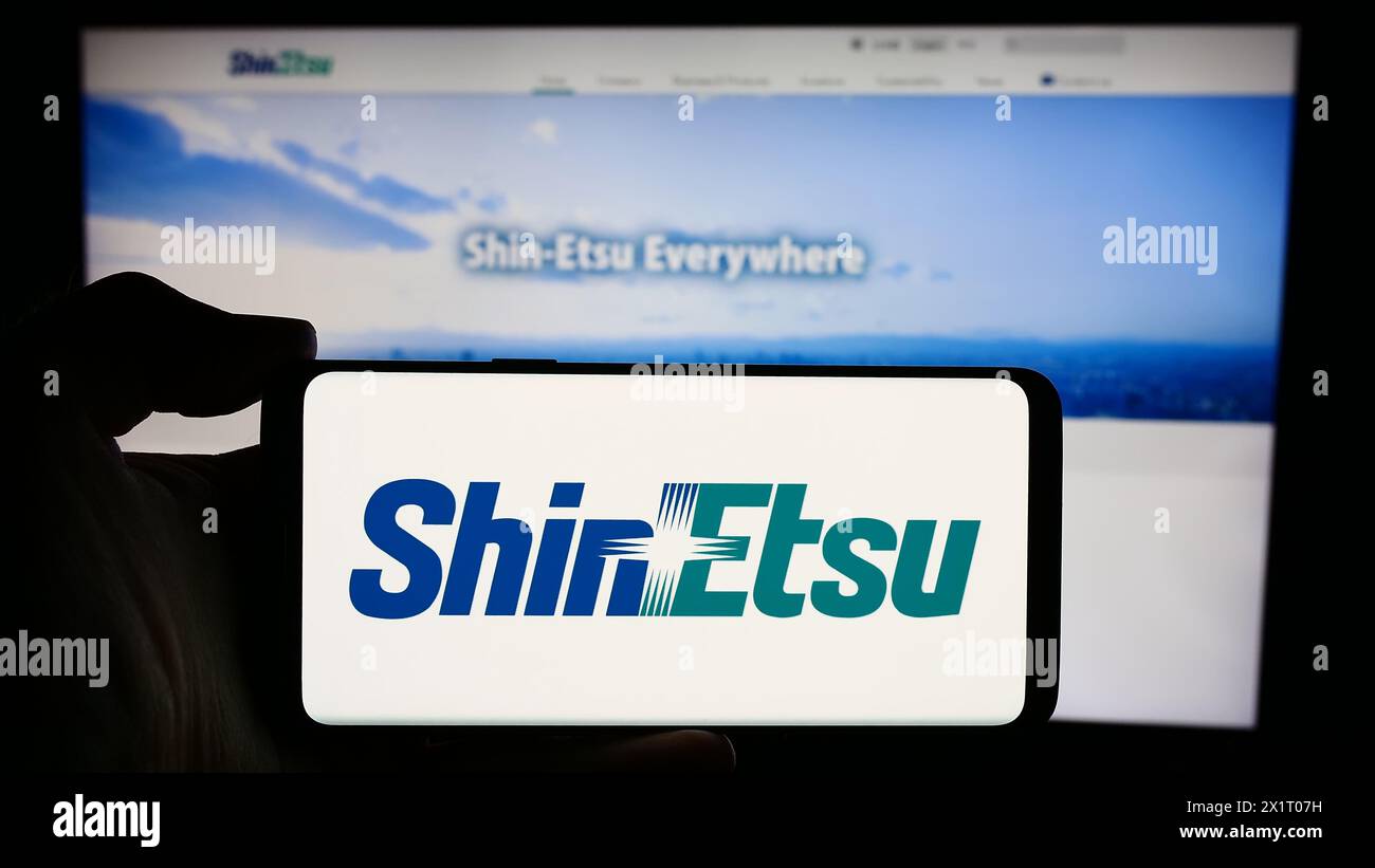 Person holding mobile phone with logo of Japanese chemicals company ...