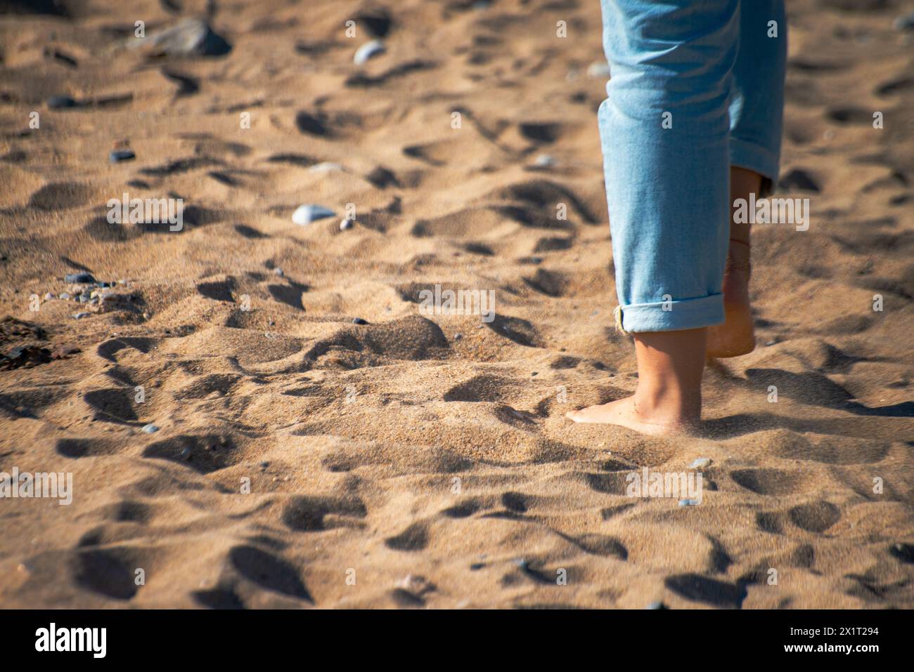 Feel the serene connection with nature as a woman strolls barefoot on ...