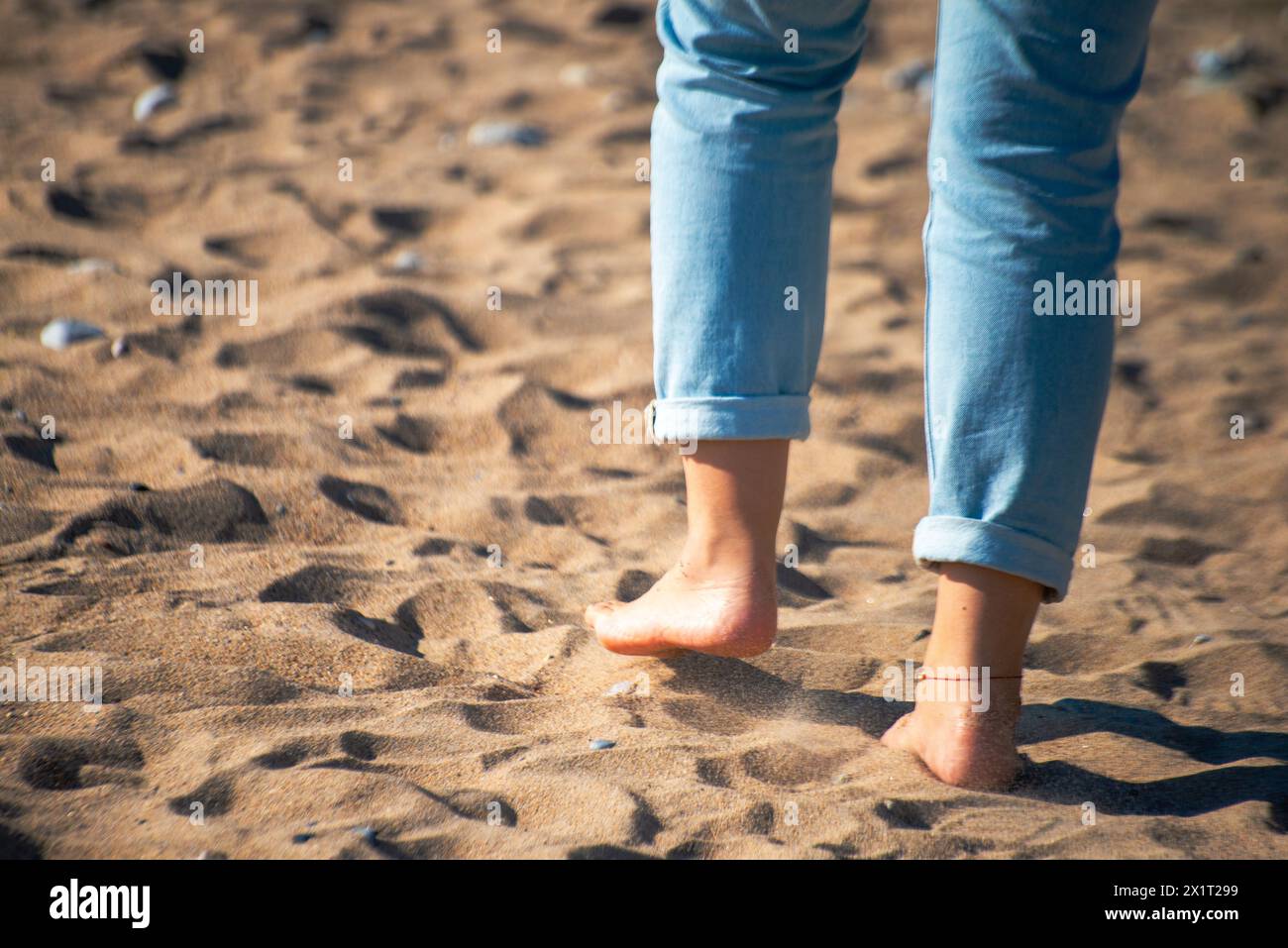 Feel the serene connection with nature as a woman strolls barefoot on ...
