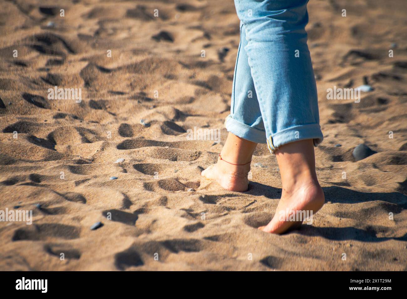Feel the serene connection with nature as a woman strolls barefoot on ...