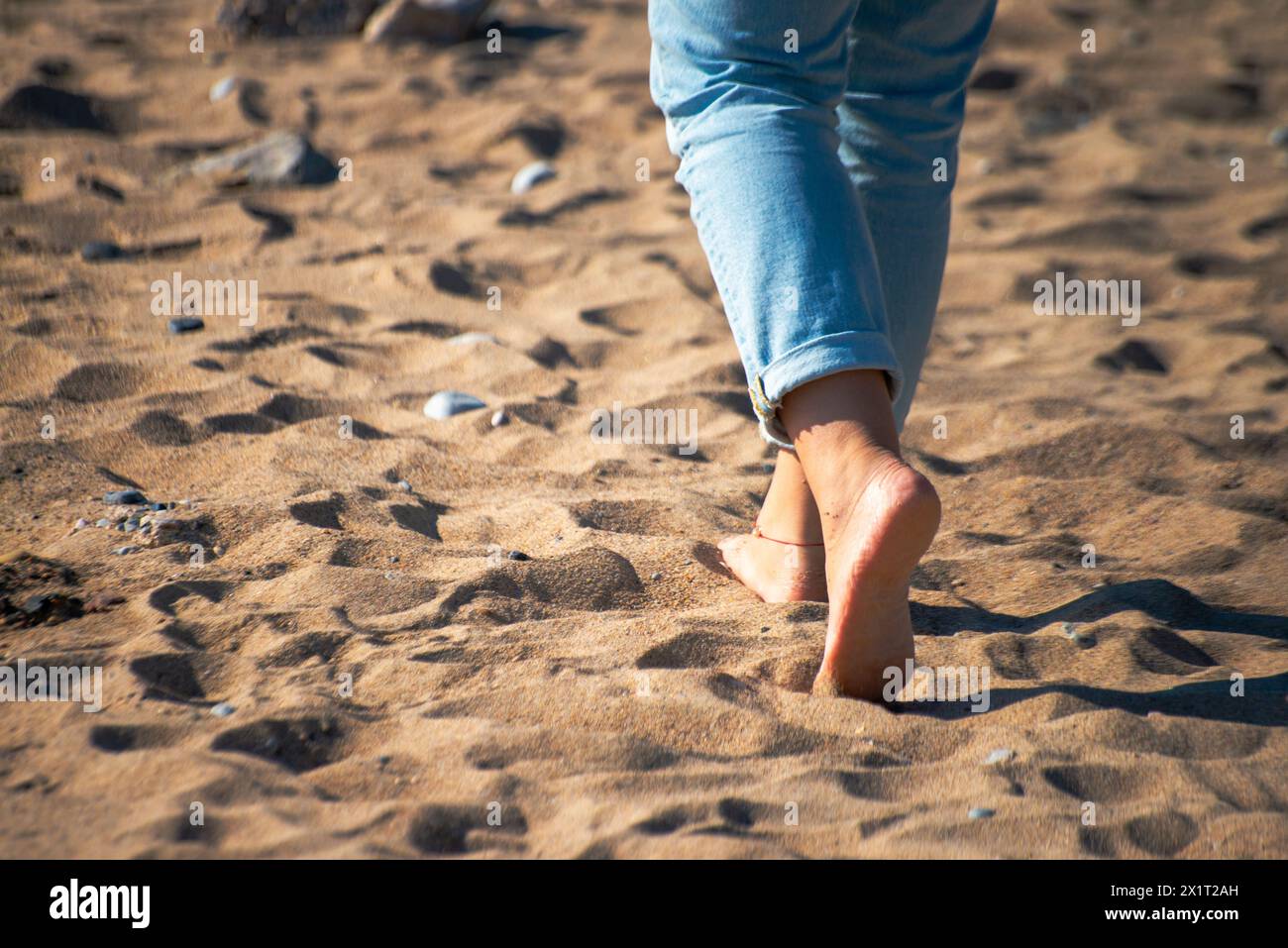 Feel the serene connection with nature as a woman strolls barefoot on ...