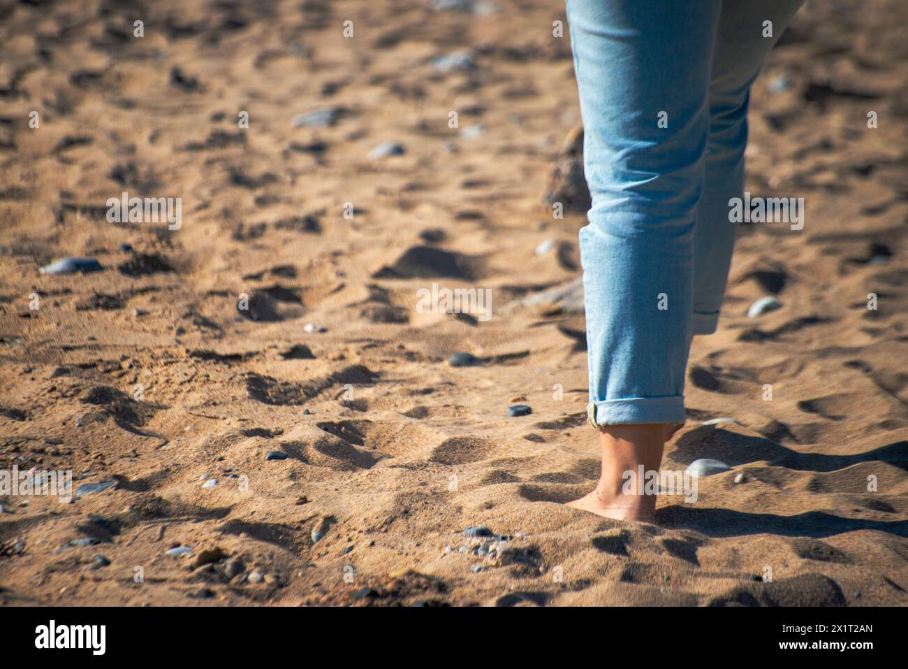 Feel the serene connection with nature as a woman strolls barefoot on ...