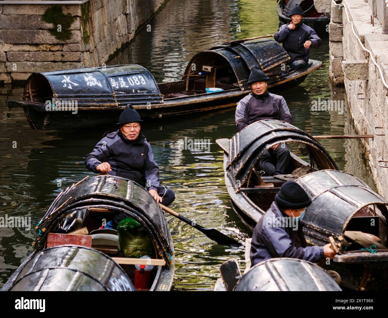 Boatmen wait for fare with their Wupeng boat along a canal in the old ...
