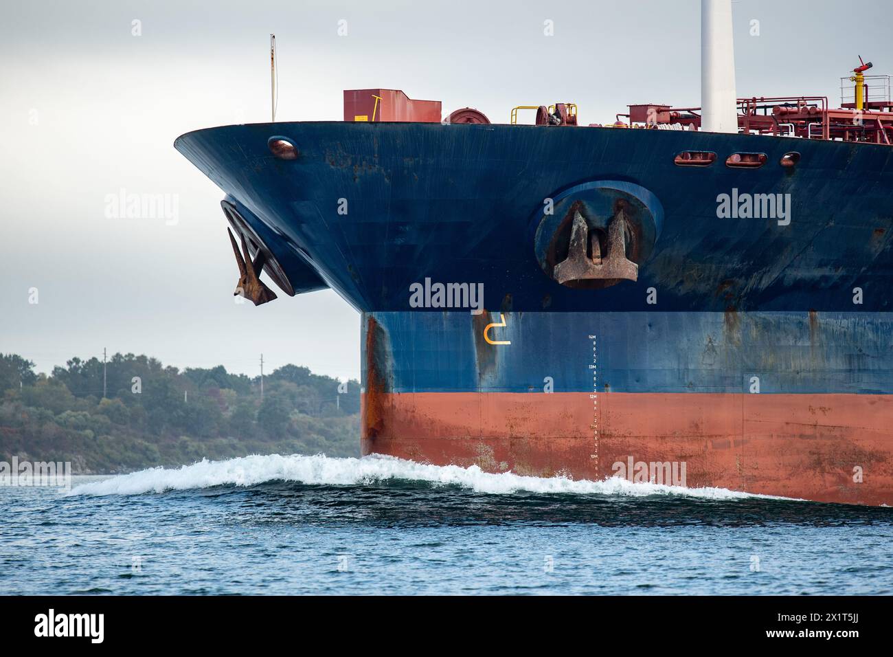 Big blue container ships bow with rusty anchors pushes a giant bow wave ...