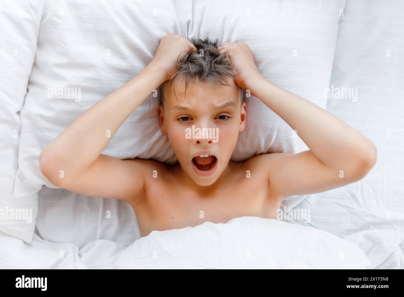 Worried awake teen boy in a bed is overslept Stock Photo - Alamy