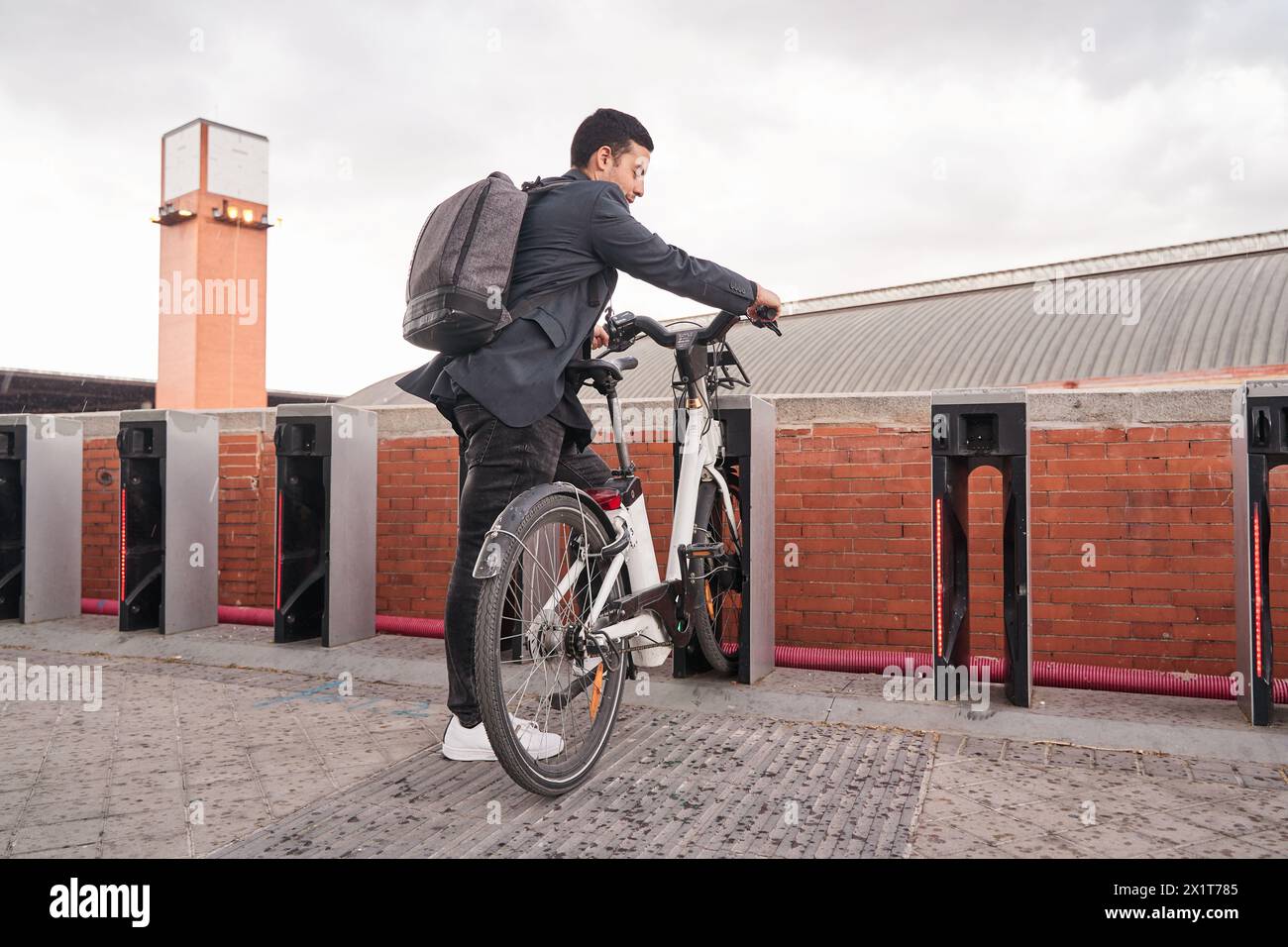 man taking a rented bicycle to get around town Stock Photo - Alamy