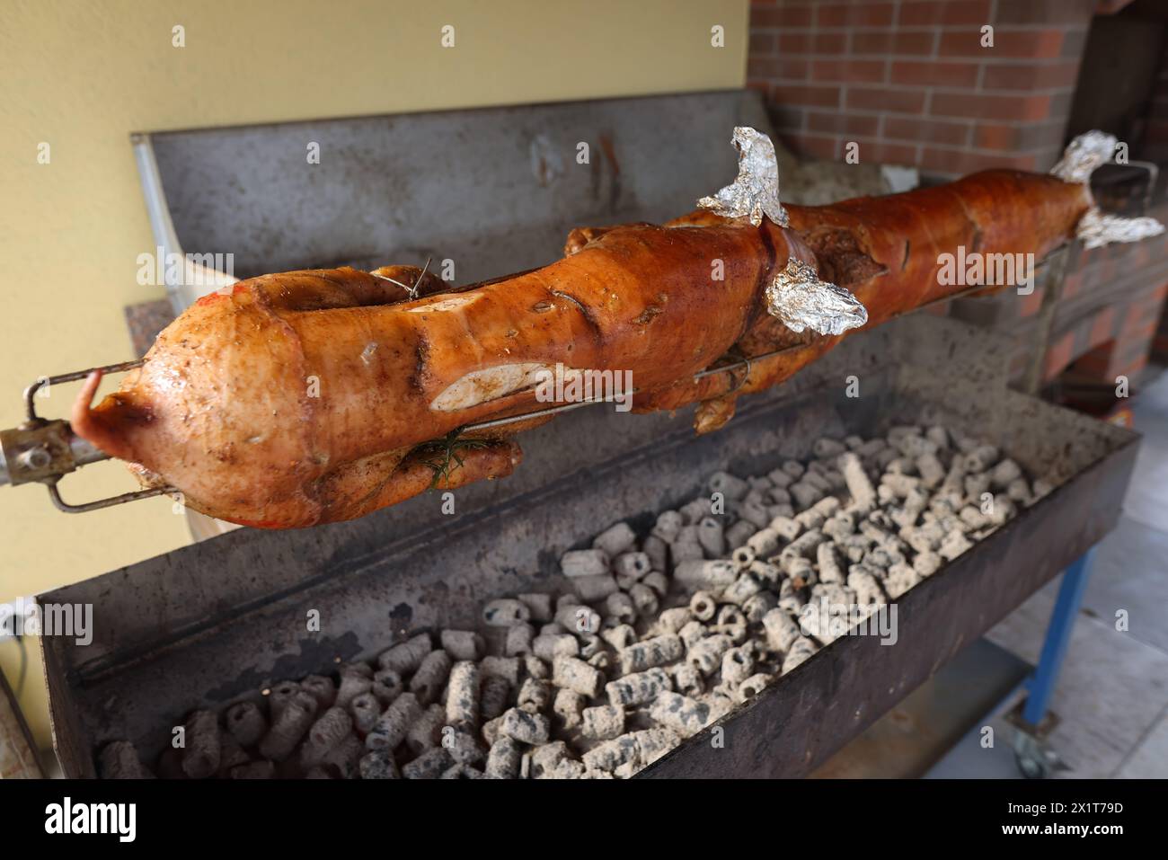 Details with suckling pigs roasting over burning coals Stock Photo - Alamy