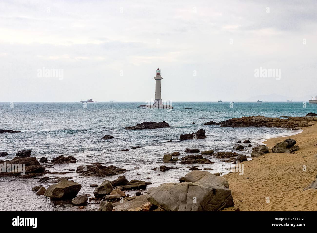 View of the lighthouse in the sea near the rocky shore. End of the ...
