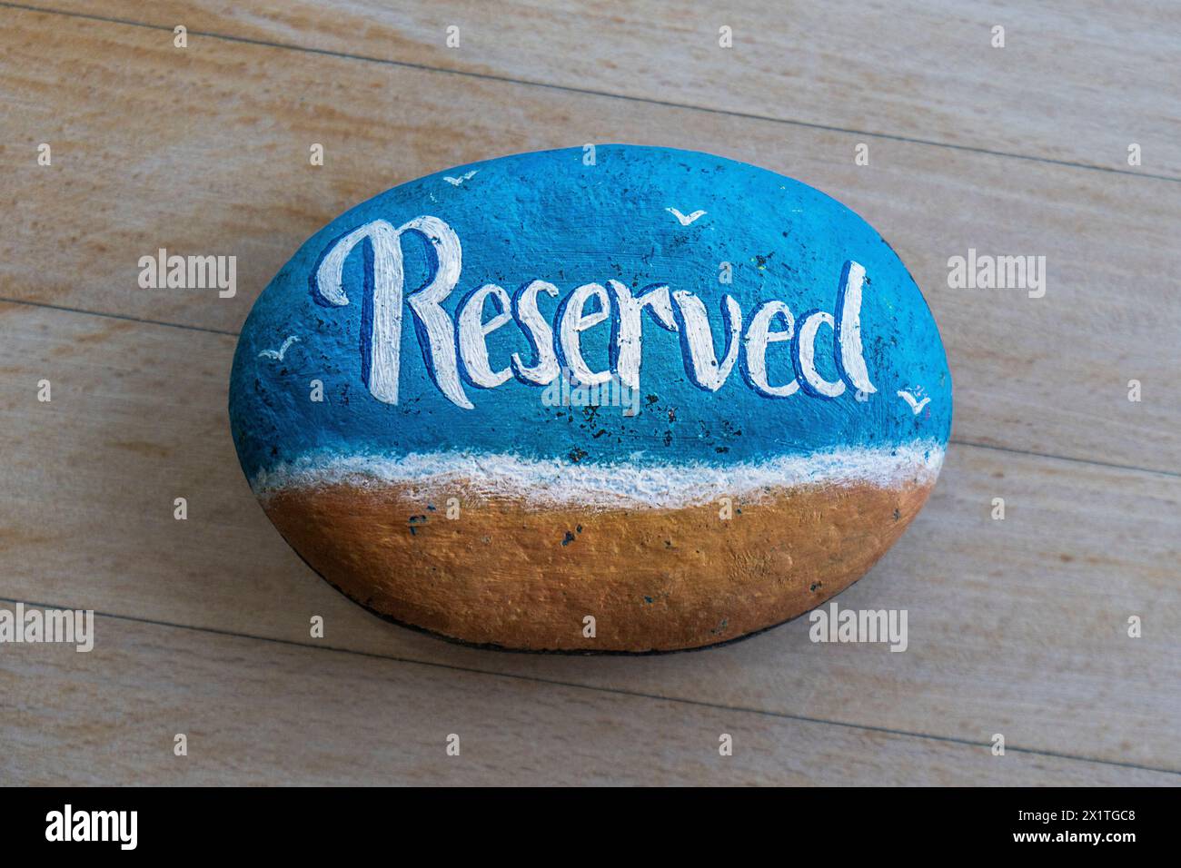 A closeup close up view of a hand painted pebble used as a reserved ...