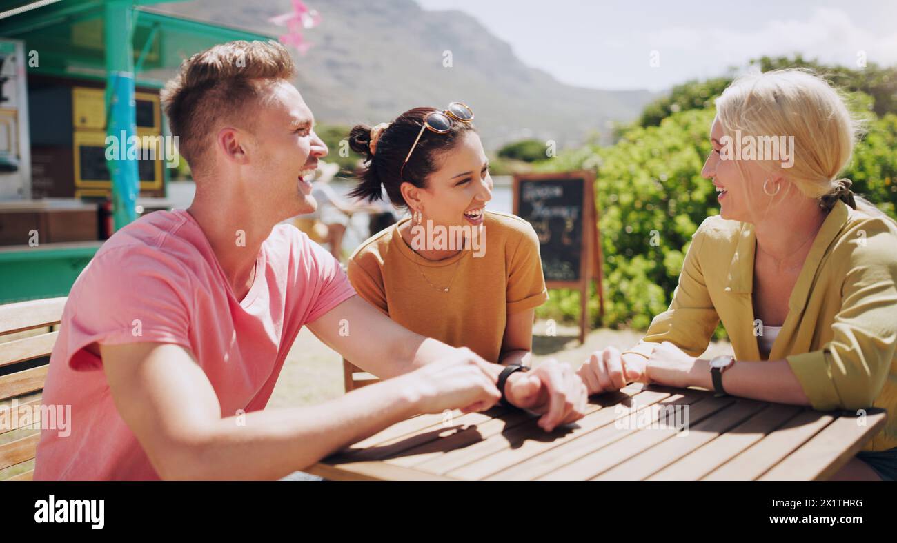 Funny, friends and talking at outdoor table of restaurant ...