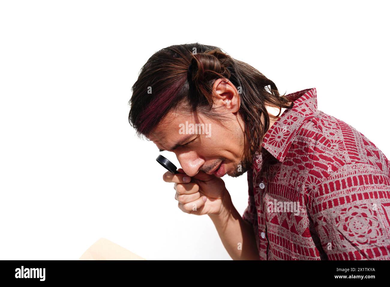 A blind man with modern hairstyle is looking through a magnifying glass ...