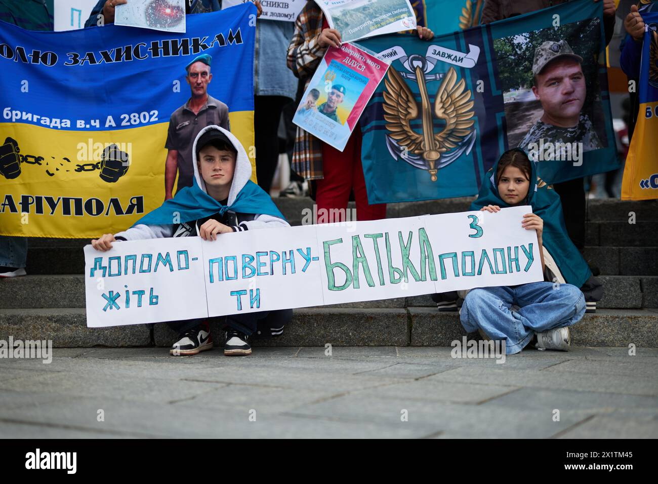 Sad Ukrainian children posing with a sign "Help Us Bring The Father ...
