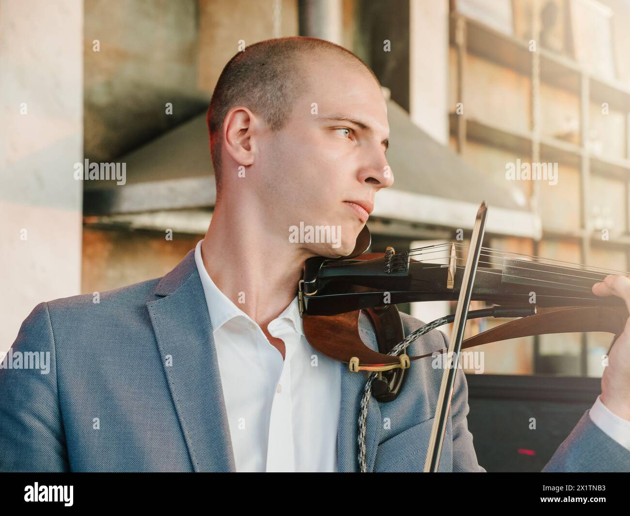 Violinist performing with electric violin in modern setting Stock Photo ...