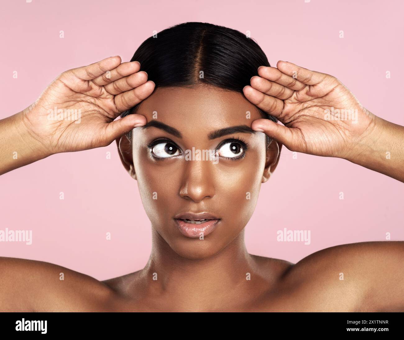 Indian woman, thinking and beauty skincare in studio on pink background ...