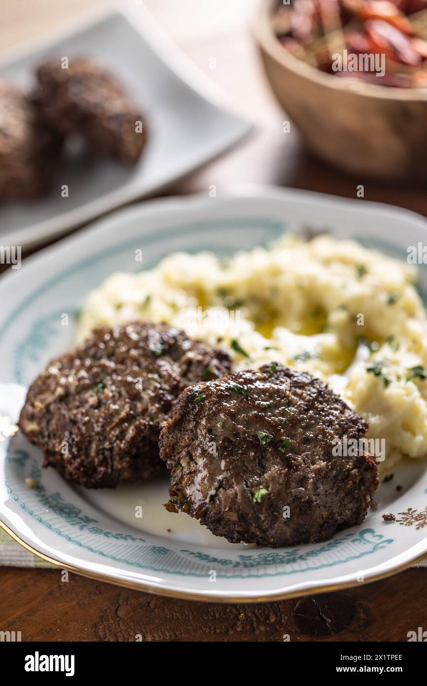 Minced meat cutlets with mashed potatoes topped with clarified butter ...