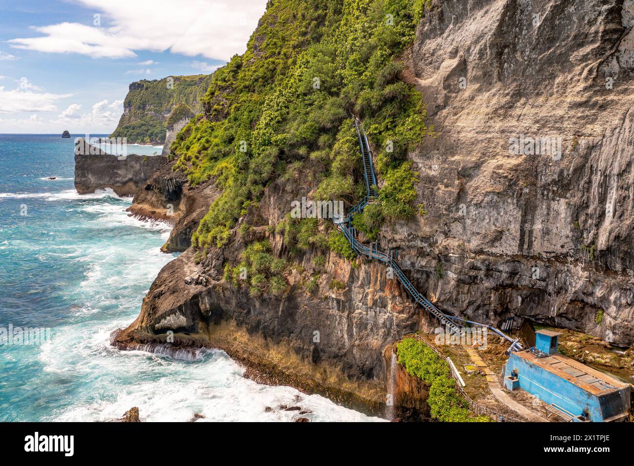 Rocks tropical vegetation, foamy ocean. Platform stairs leading up ...