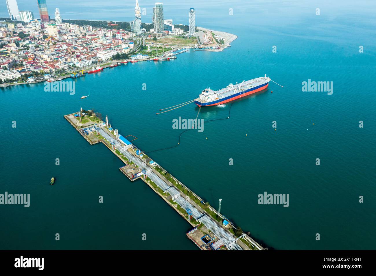 Fuel tanker docked at port with cityscape backdrop, securing vital ...