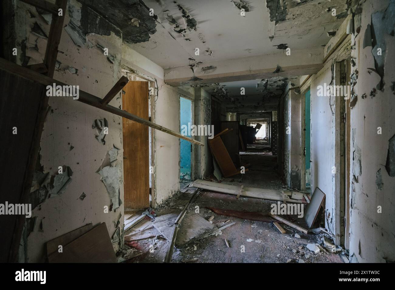 Hallway of desolation in abandoned building, peeling paint and debris ...