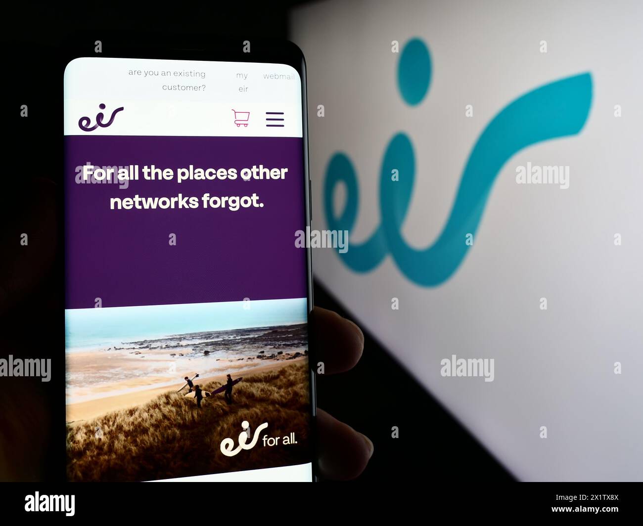 Person holding mobile phone with web page of Irish telecommunications ...