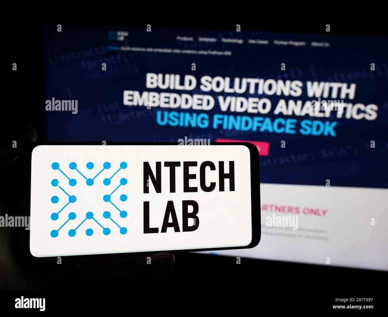 Person holding smartphone with logo of Russian facial recognition company NtechLab (Findface) in ...