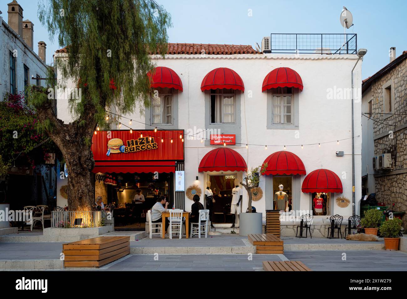 White building with red awnings in Alacati, Turkey Stock Photo - Alamy