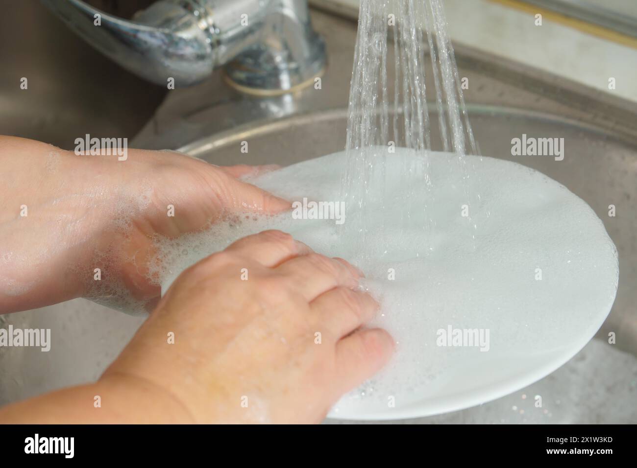 Washing dishes in kitchen sink hi-res stock photography and images - Alamy