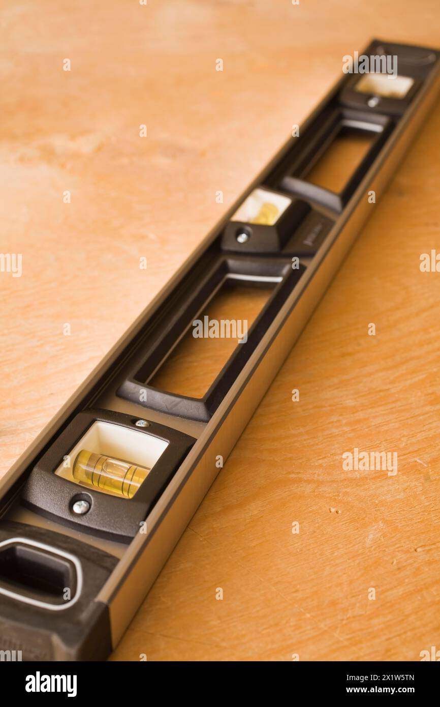 Close-up of black plastic and aluminum spirit level tool on plywood ...