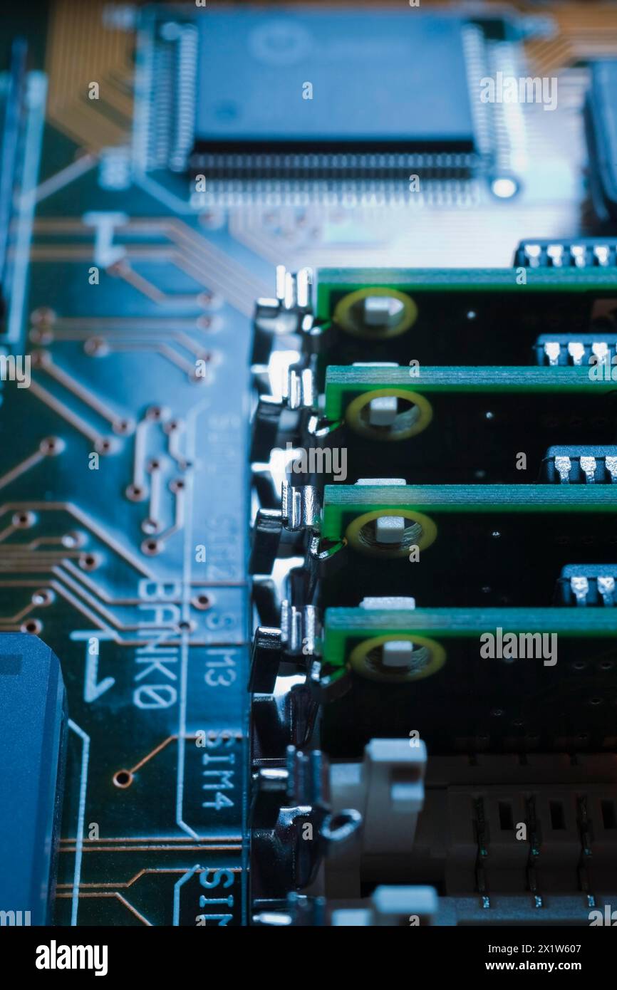 Close-up of blue and green lighted electronic computer circuit board with memory chip and lines ...