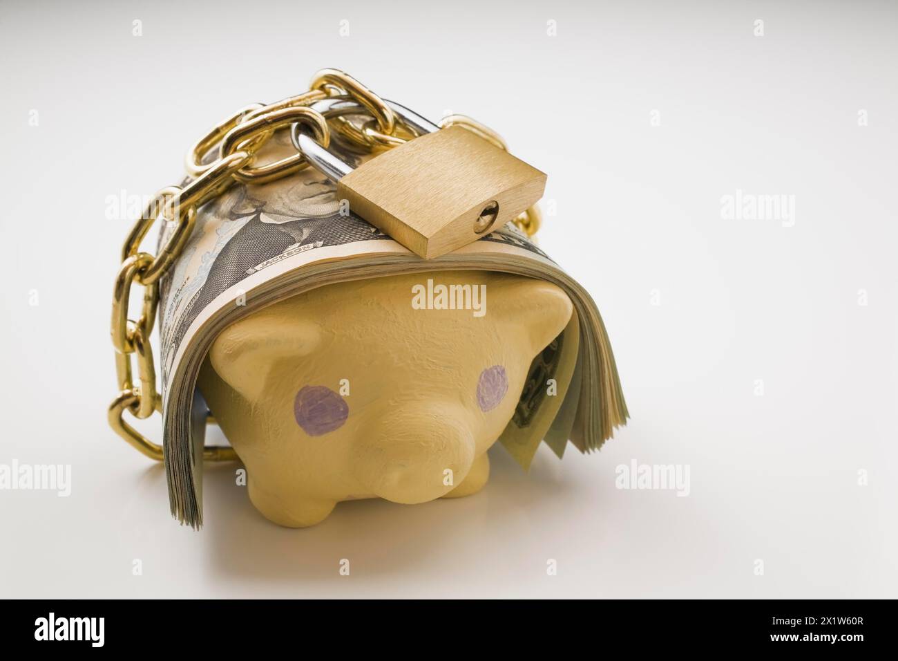 Close-up of wad of US currency bank notes wrapped with a brass chain ...