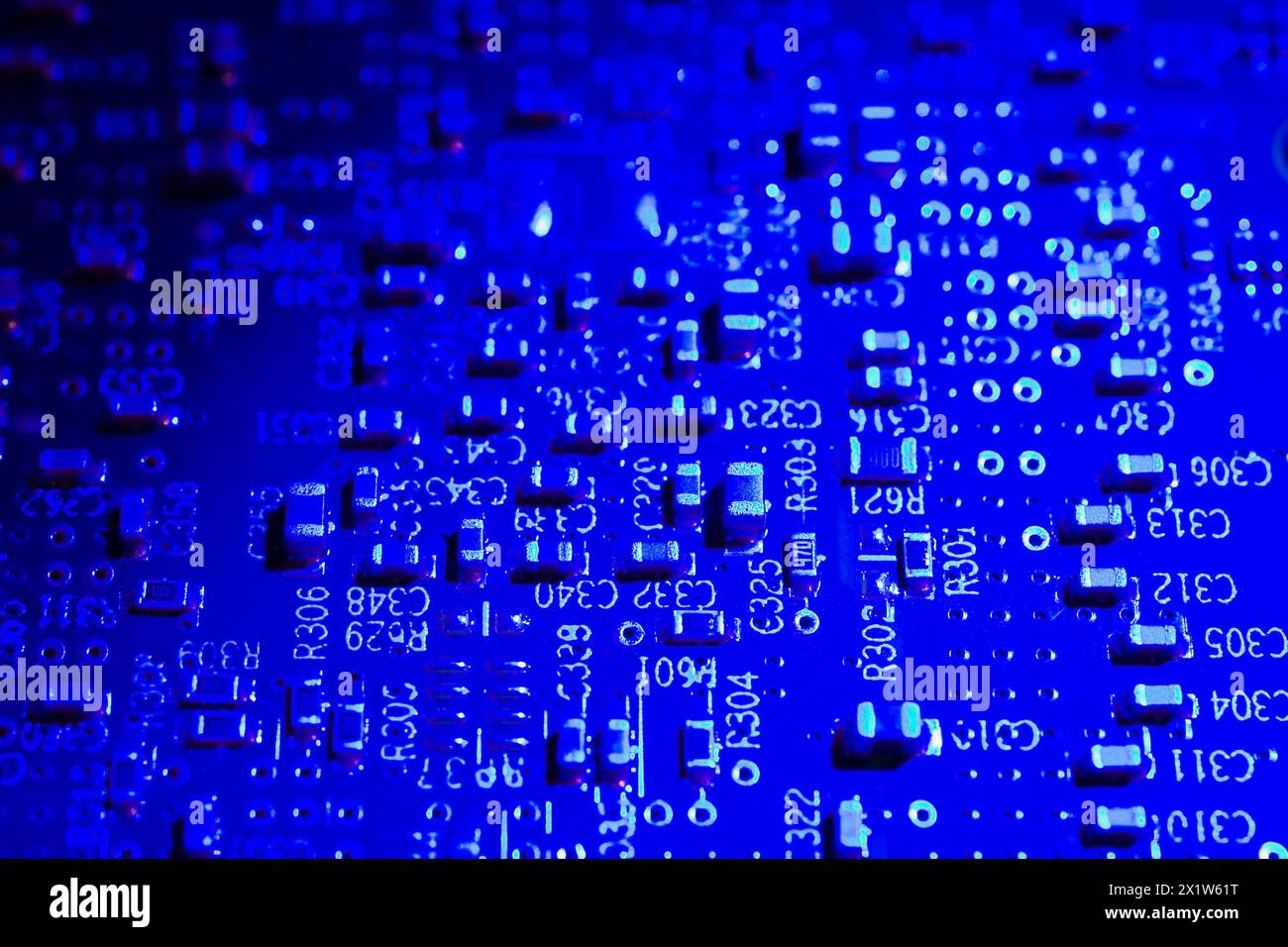 Close-up of blue lighted electronic computer circuit board with white numbers and letters ...
