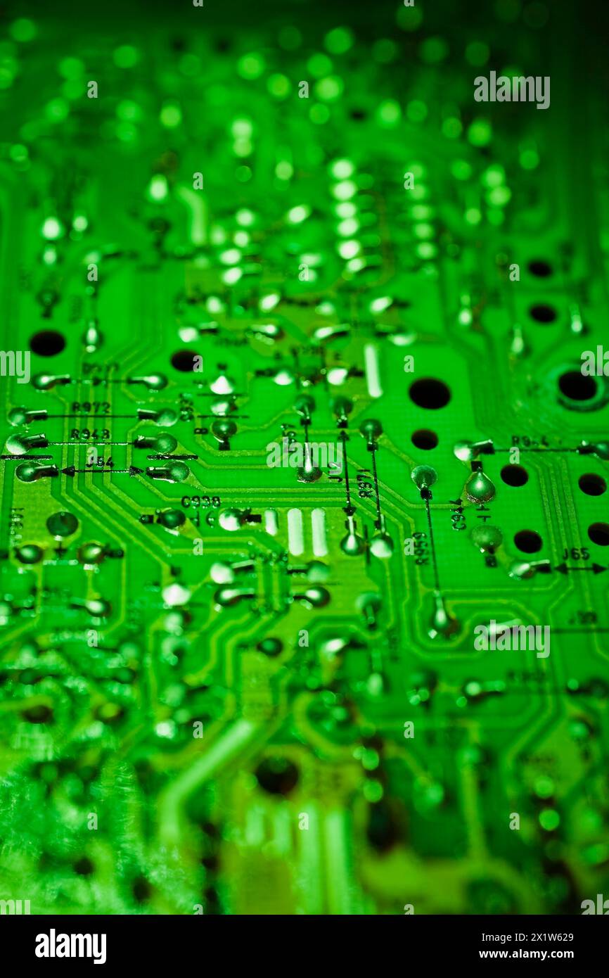 Close-up of green lighted electronic computer circuit board with silver ...