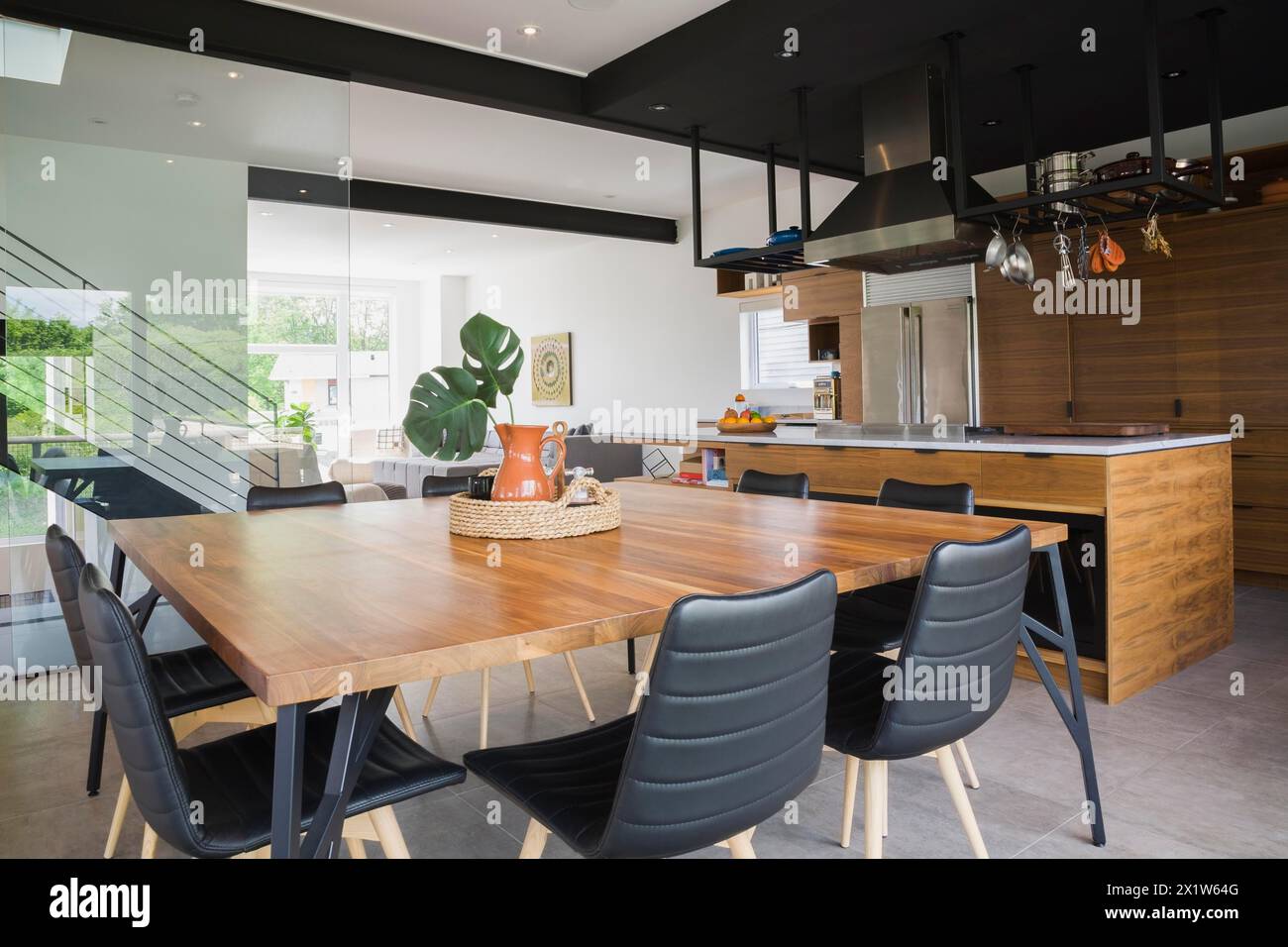 American walnut wood dining table and black leather sitting chairs with ...