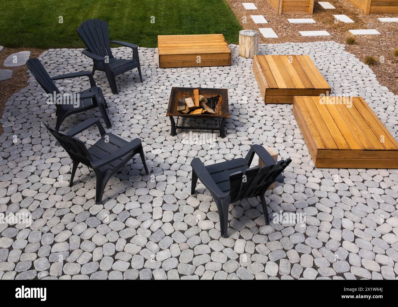 Grey paving stone patio with black Adirondack sitting chairs, slightly ...