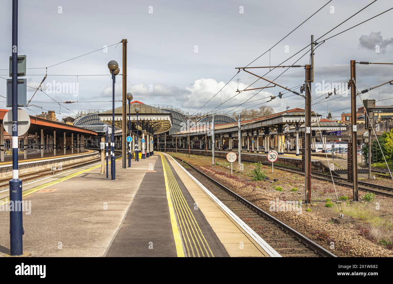 View of a railway station with a lamp post in the foreground. The ...